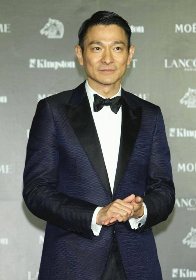 Andy Lau and Na Ying are on the same stage, wearing a black suit with a ...