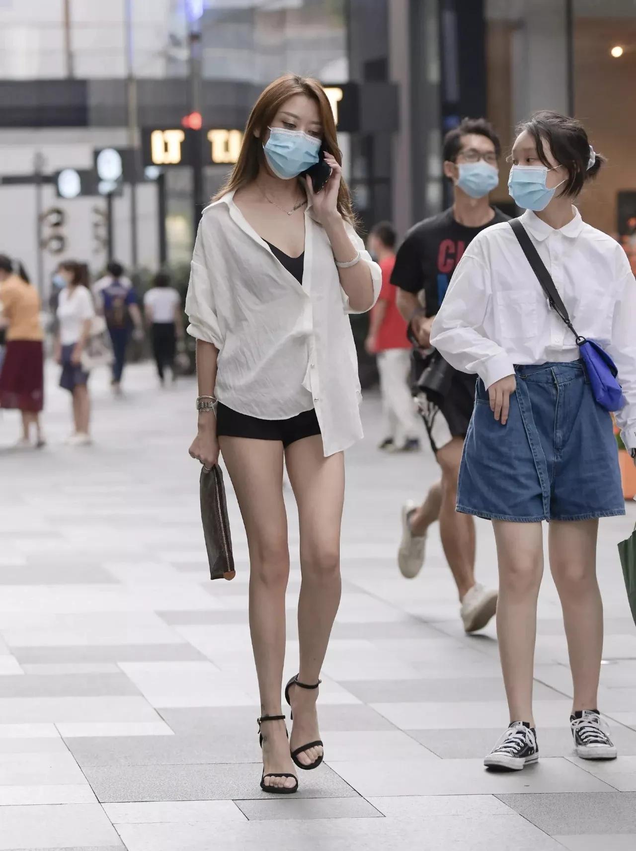 Street shot: fashionable girls in white, white shirts, black shorts and ...