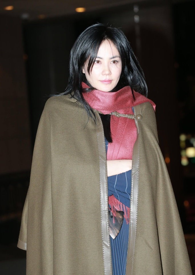 Faye Wong wears clothes randomly, wearing a green cloak and red scarf, relying on her face to ...